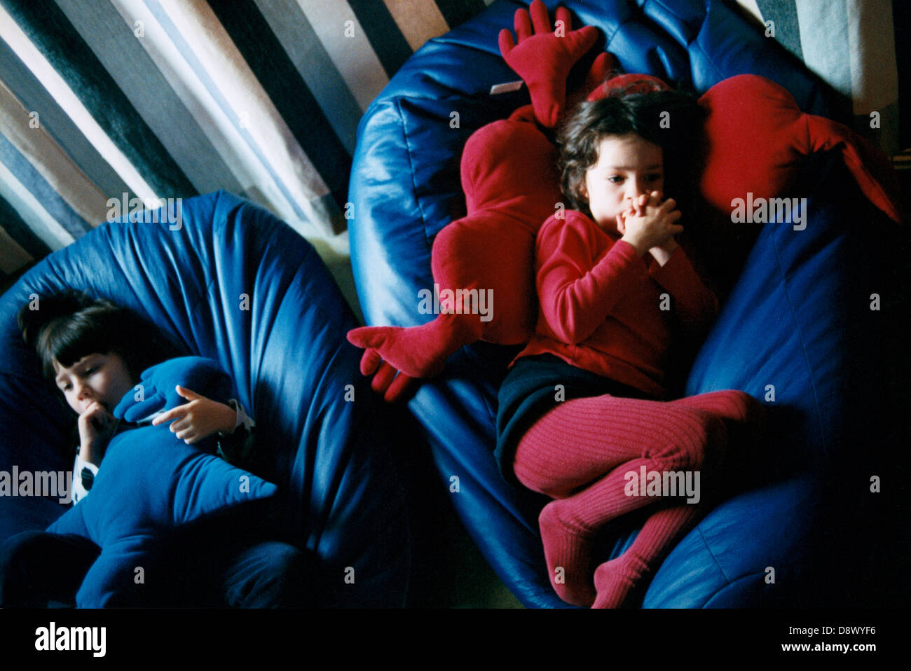Two tired children falling asleep in bean bags Stock Photo - Alamy