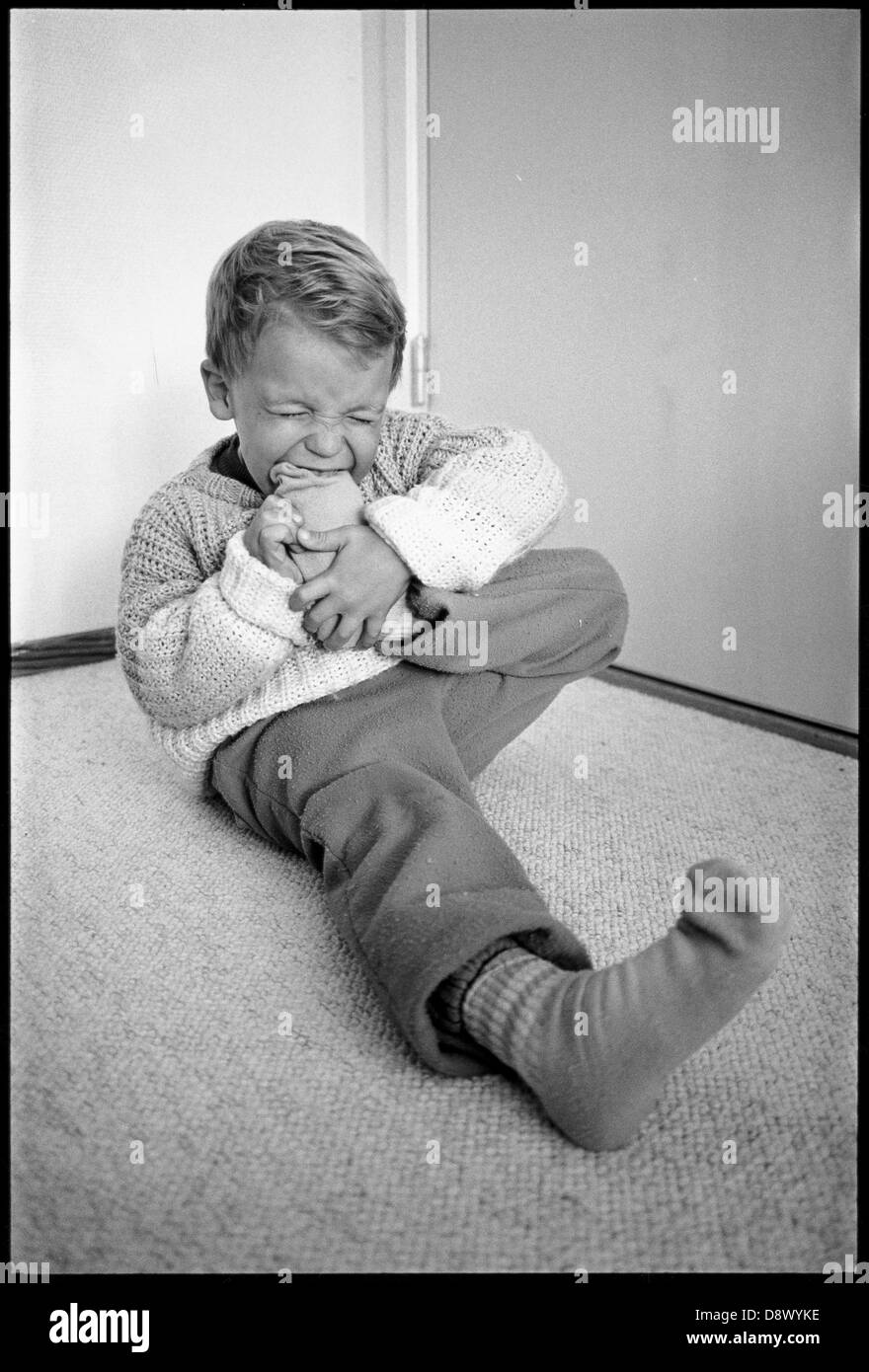 A boy biting his foot Stock Photo - Alamy