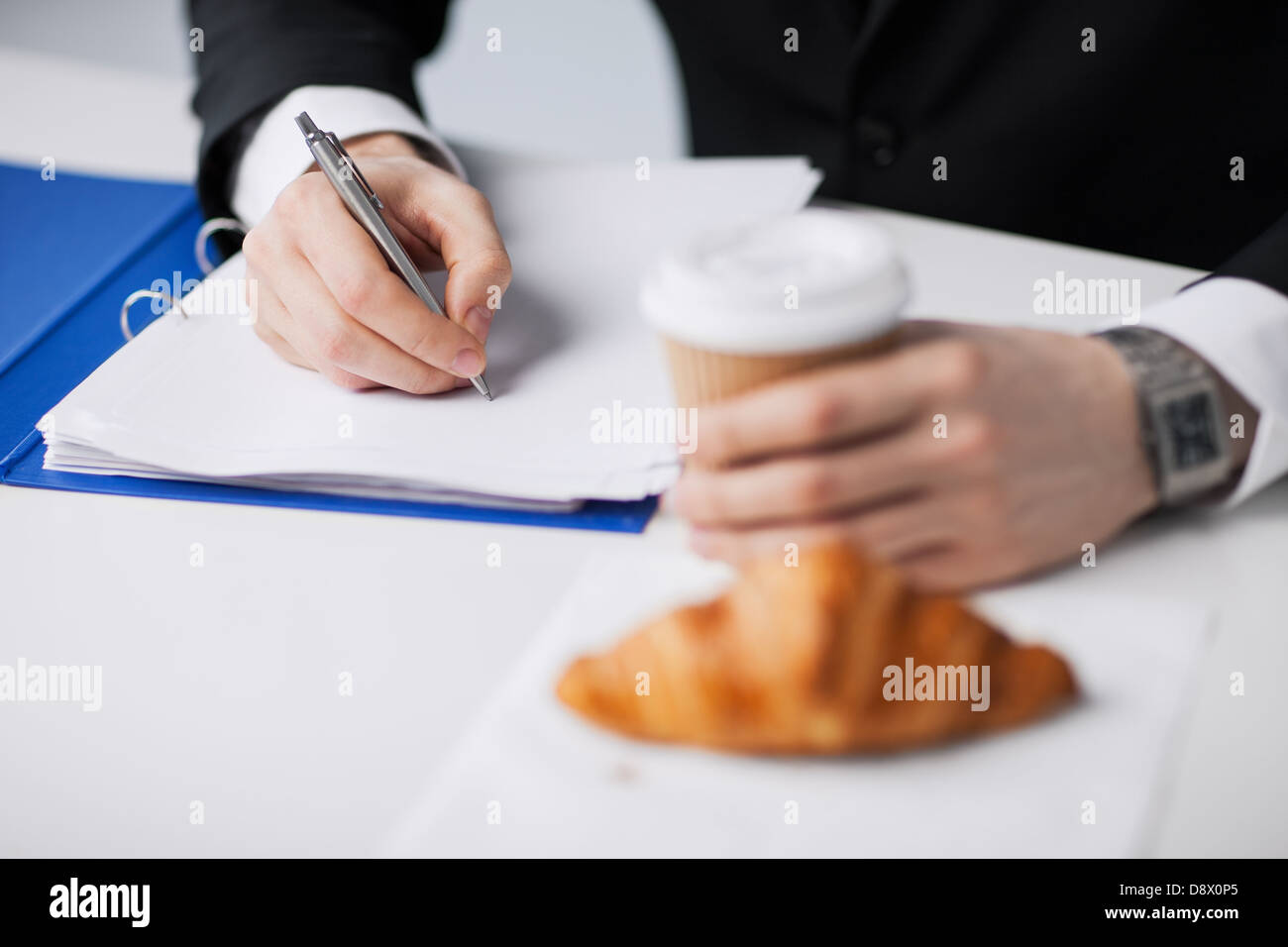 businessman with coffee writing something Stock Photo - Alamy