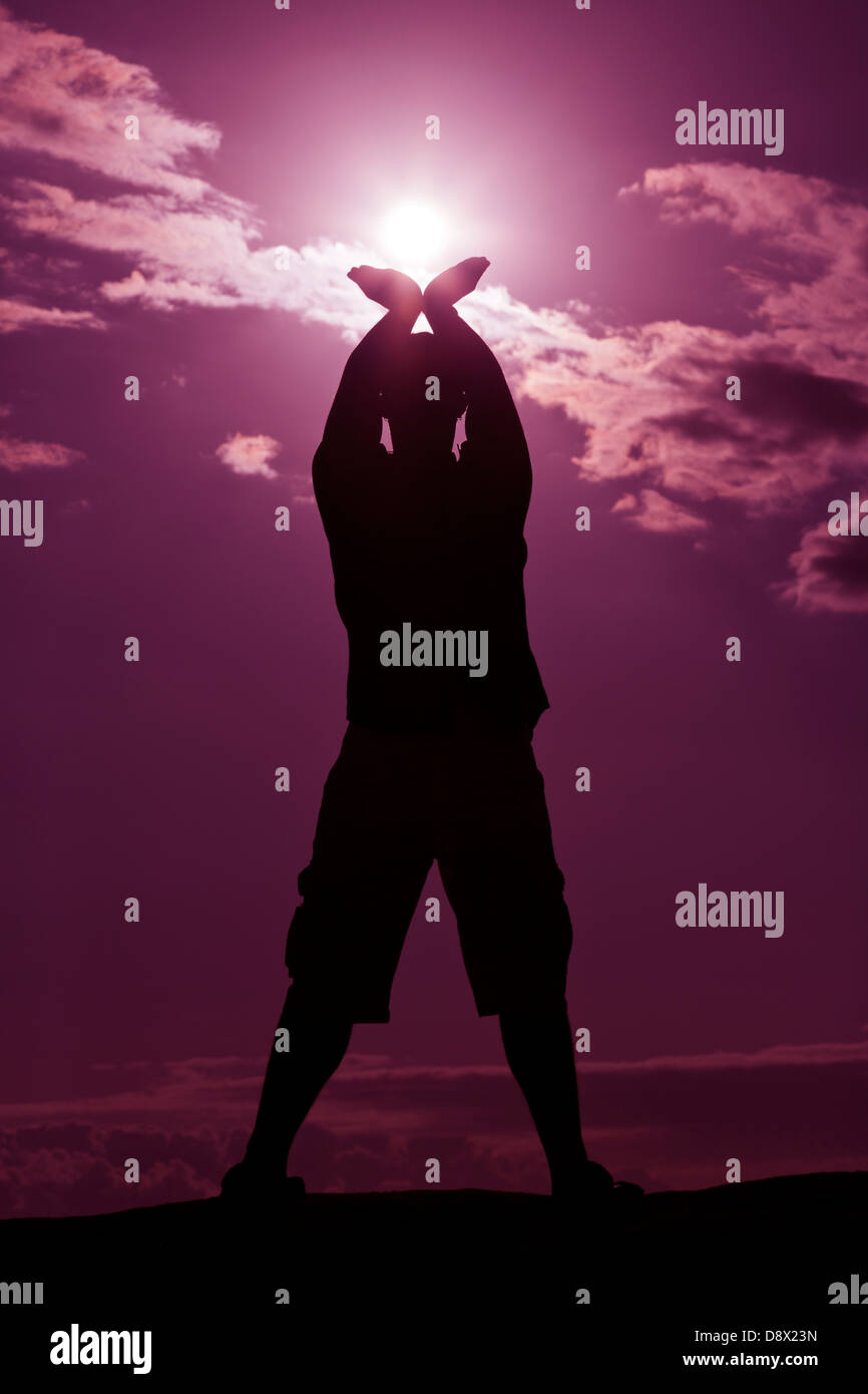 Silhouette of male holding the sun above his head Stock Photo - Alamy