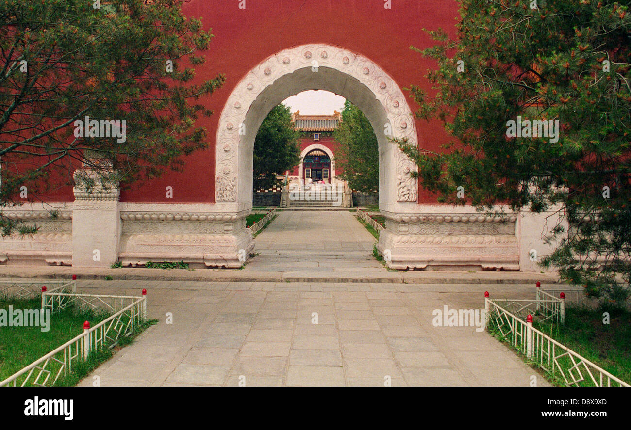 Pathway leading through arched structure towards building Stock Photo ...
