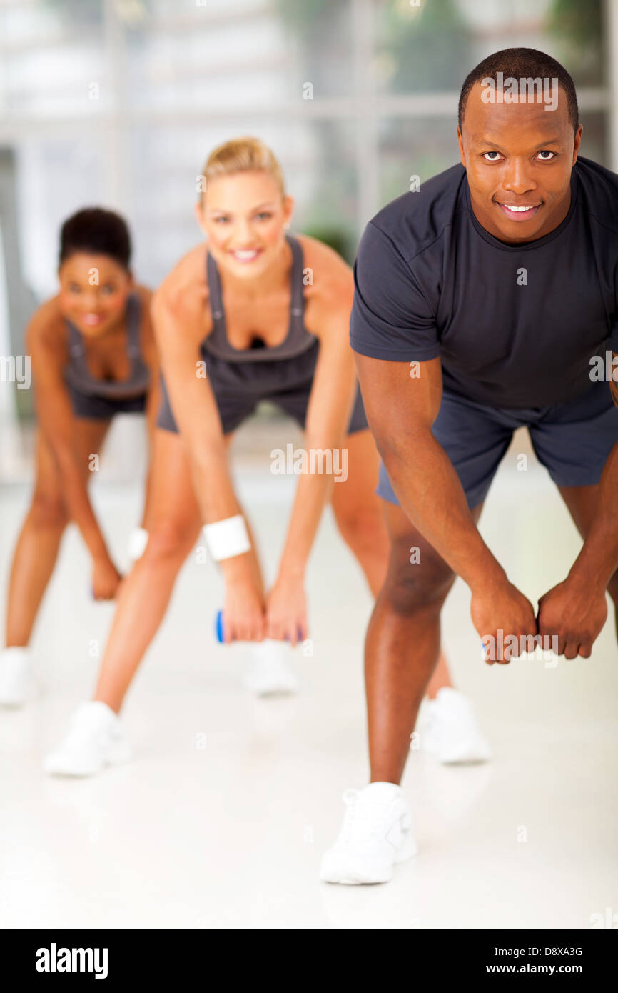 group of healthy people doing fitness exercise with dumbbell in gym ...