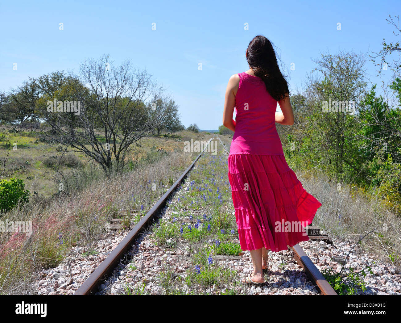 Girl walking on rail track Stock Photo - Alamy