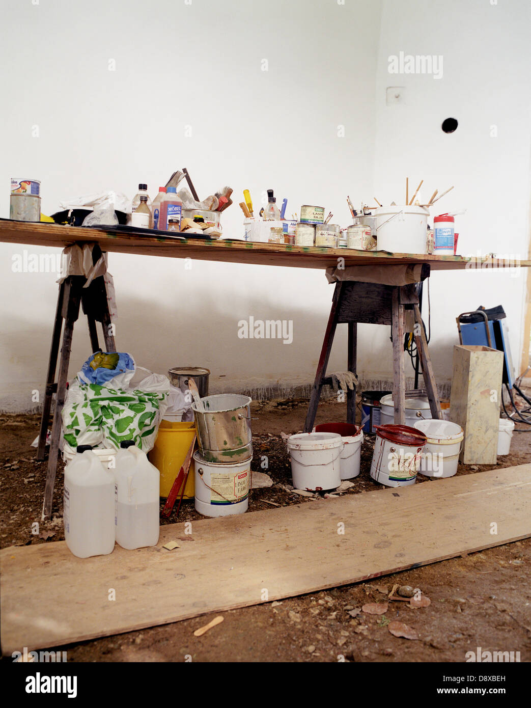 A worktable with paint in buckets and cans Stock Photo - Alamy