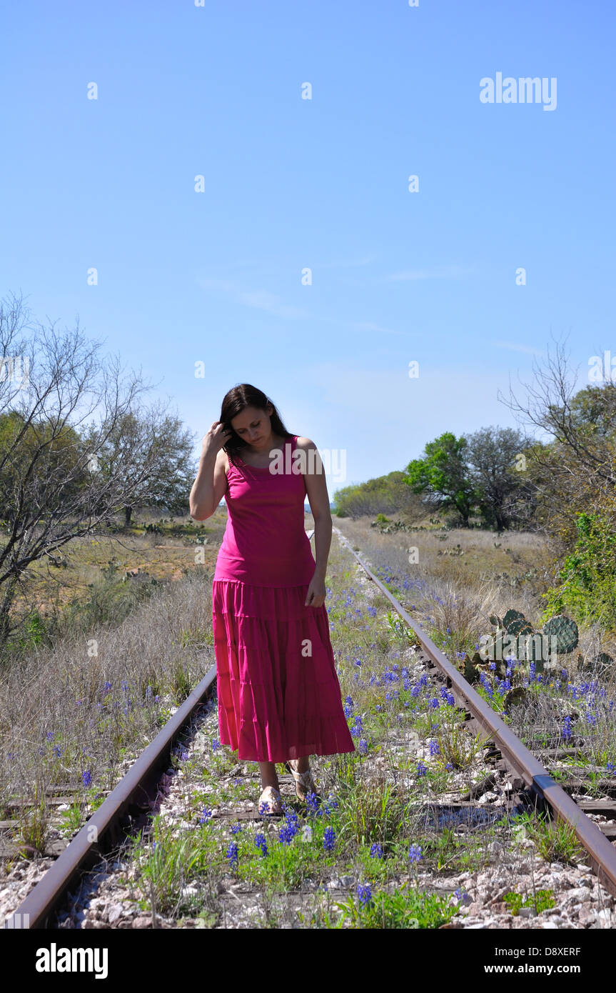 Girl walking on rail track Stock Photo - Alamy