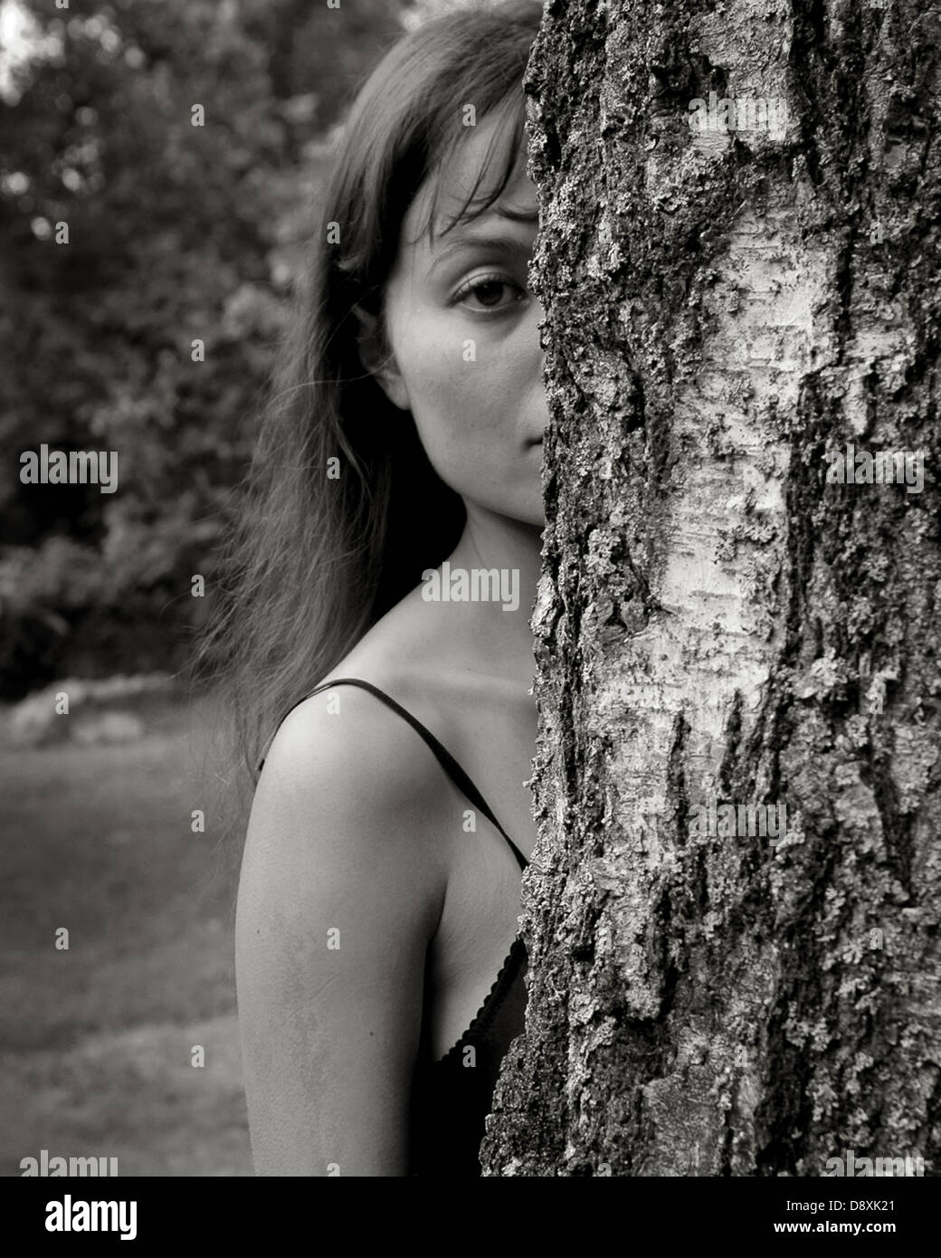 A Girl Hiding behind a Tree Trunk Stock Photo - Alamy