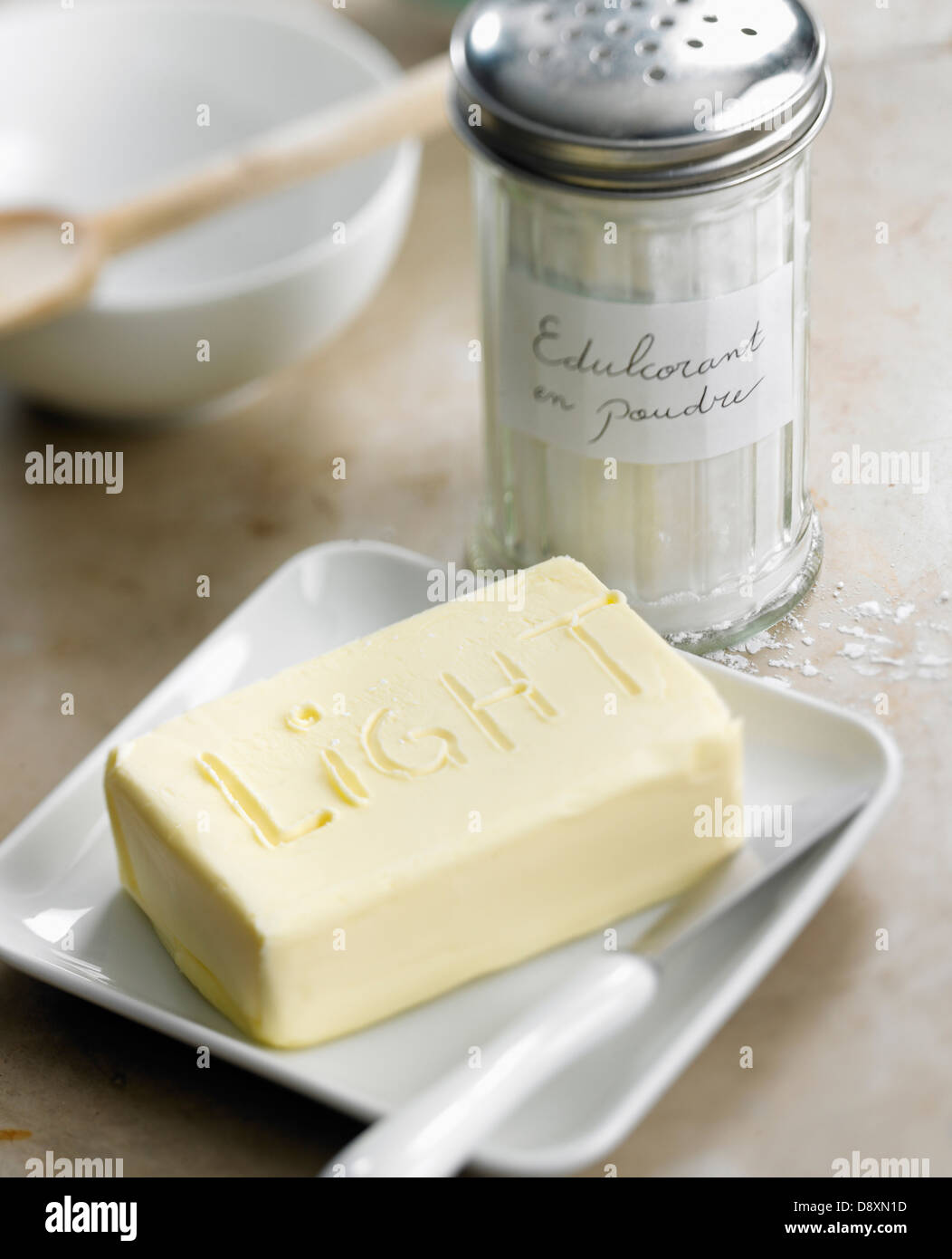 Slab of low-fat butter and a shaker of sweetening agent Stock Photo - Alamy