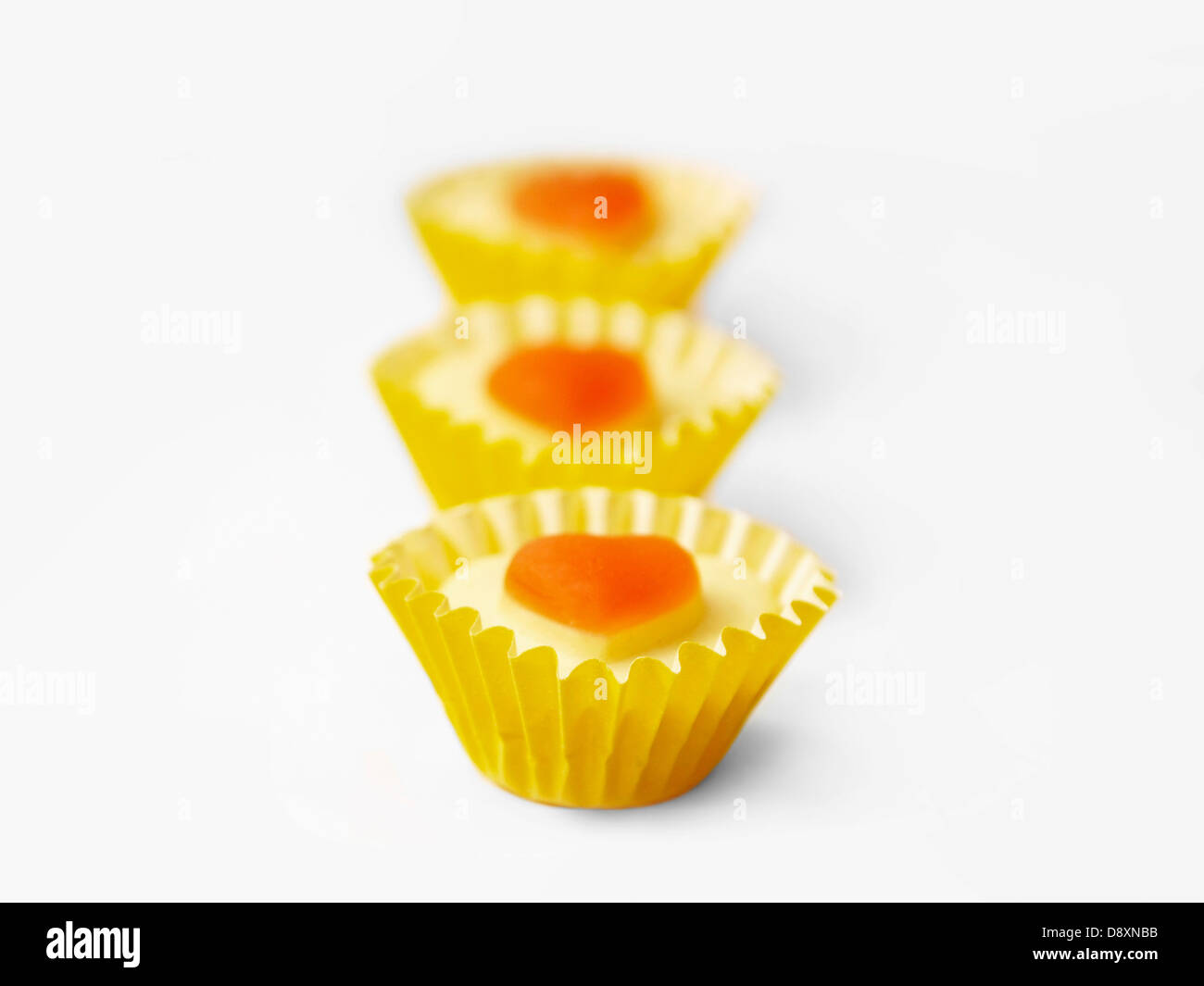 Small orange candies in paper cups Stock Photo - Alamy