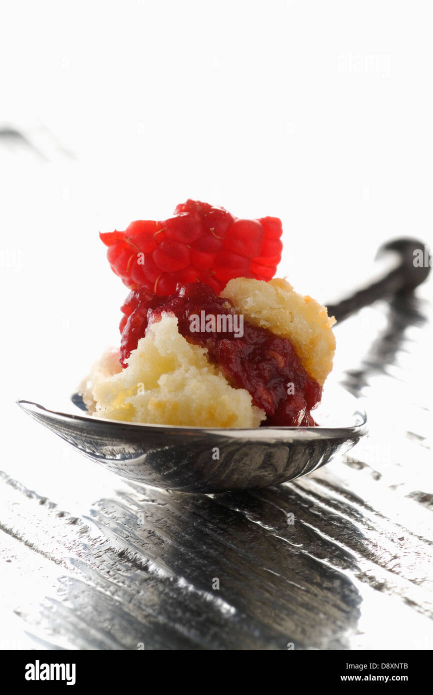 Spoonful of cake with raspberry puree Stock Photo - Alamy