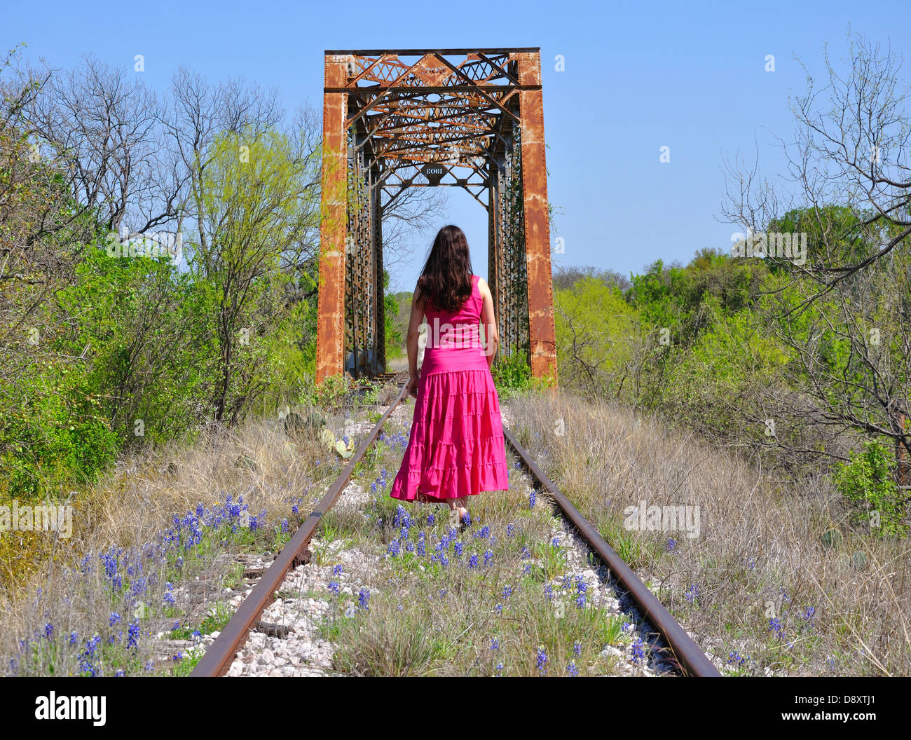 Girl walking on rail track Stock Photo - Alamy