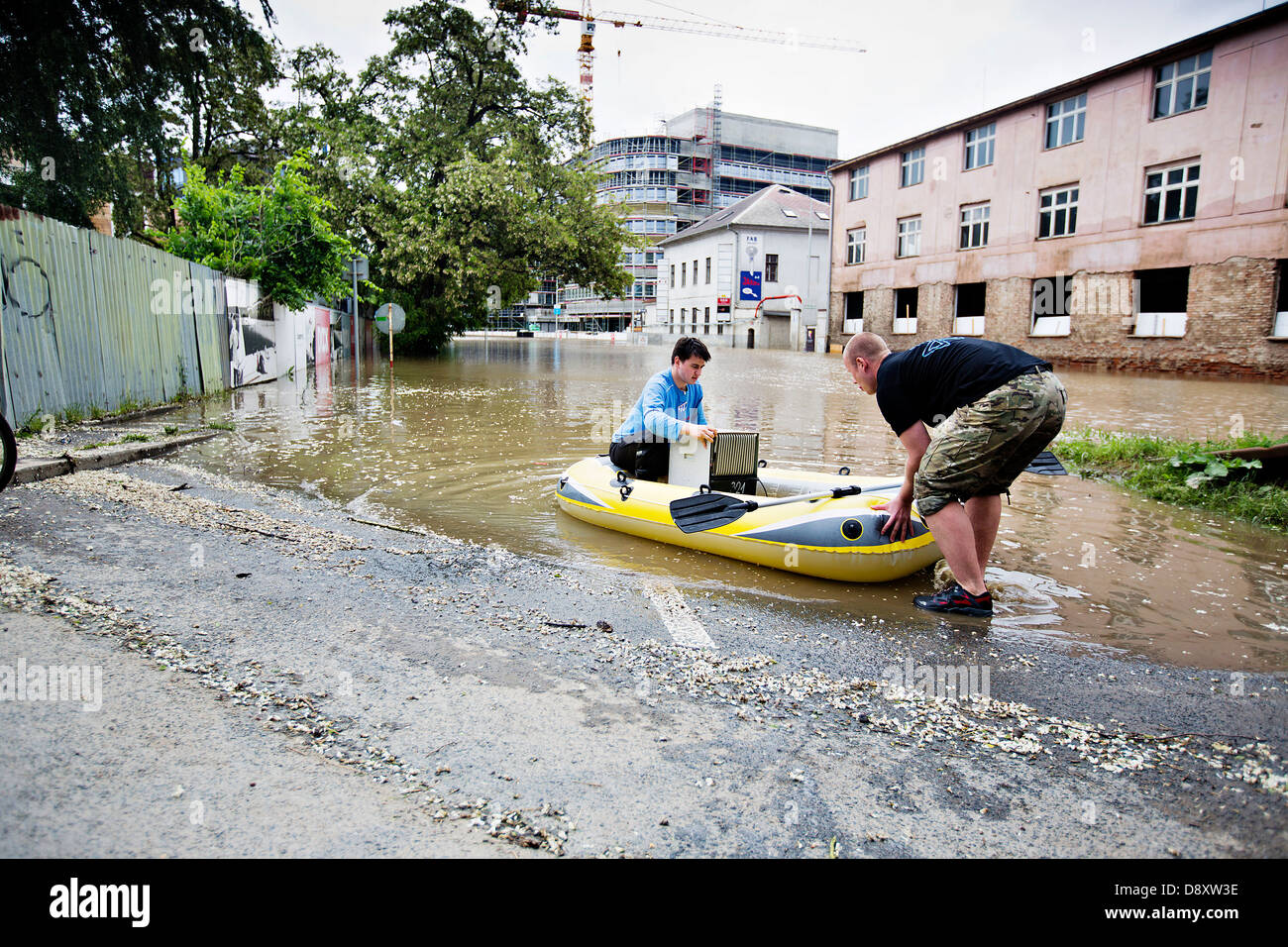Men transport on rubber dinghy dehumidifier on their way to flooded ...