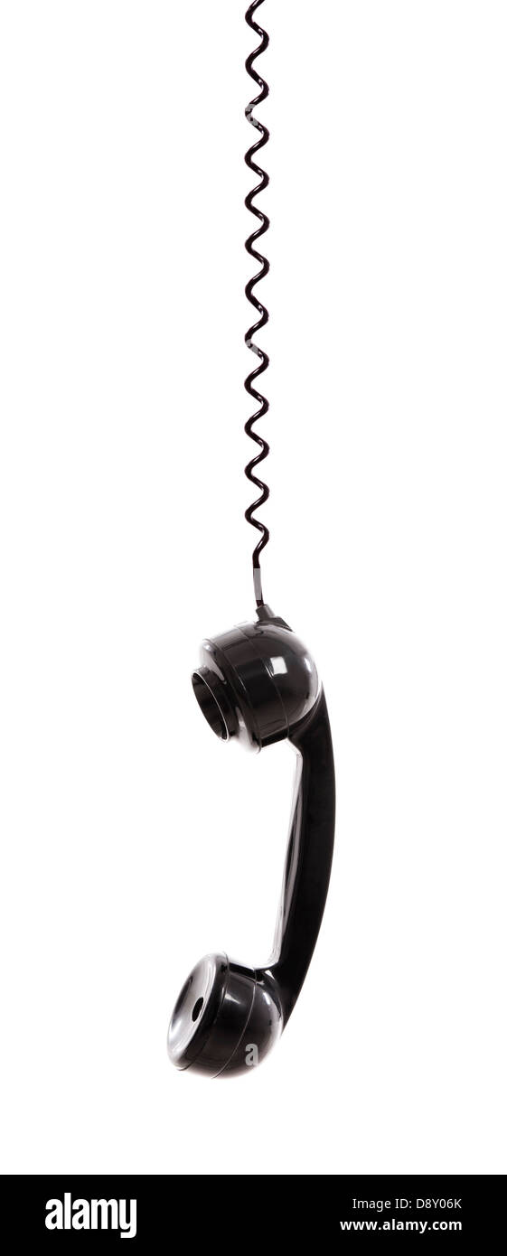 Handset piece from an old phone suspended by the phone cord, isolated ...