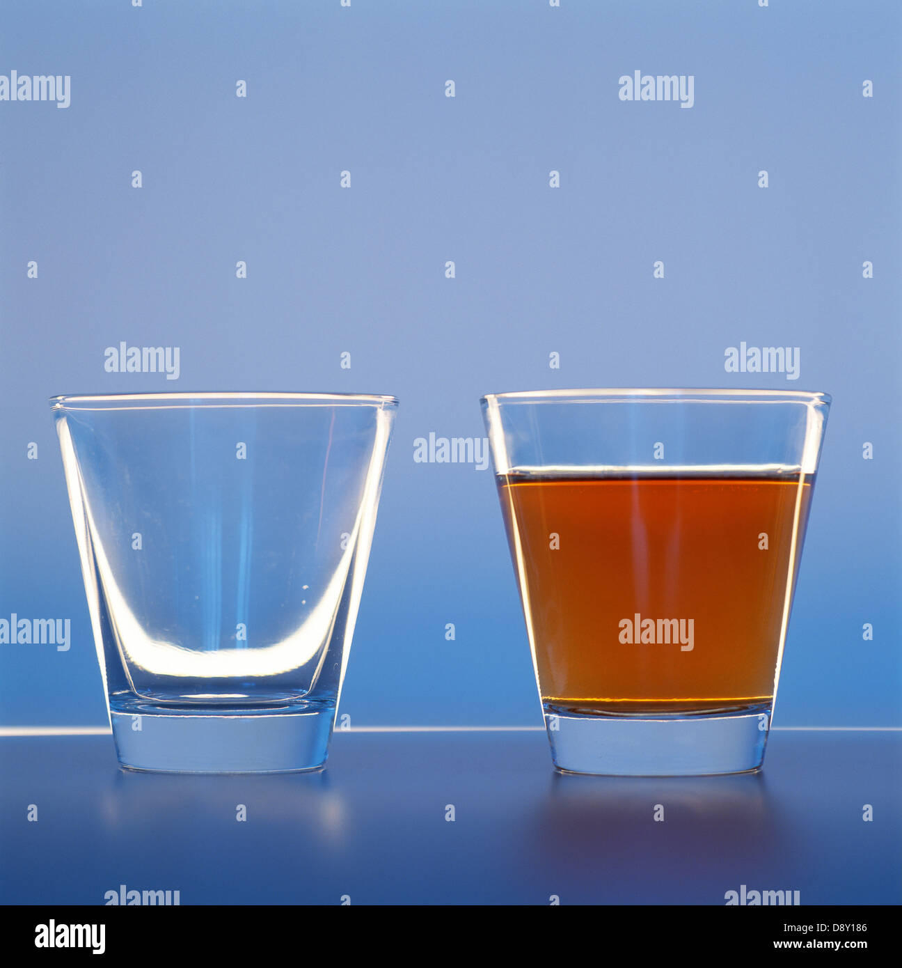 A Empty Glass and a Full Glass with Blue Background Stock Photo - Alamy