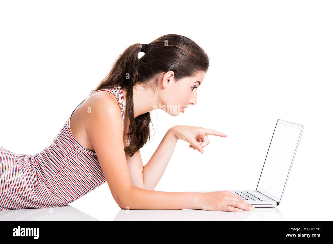 Happy student lying in the floor working and pointing to a laptop ...