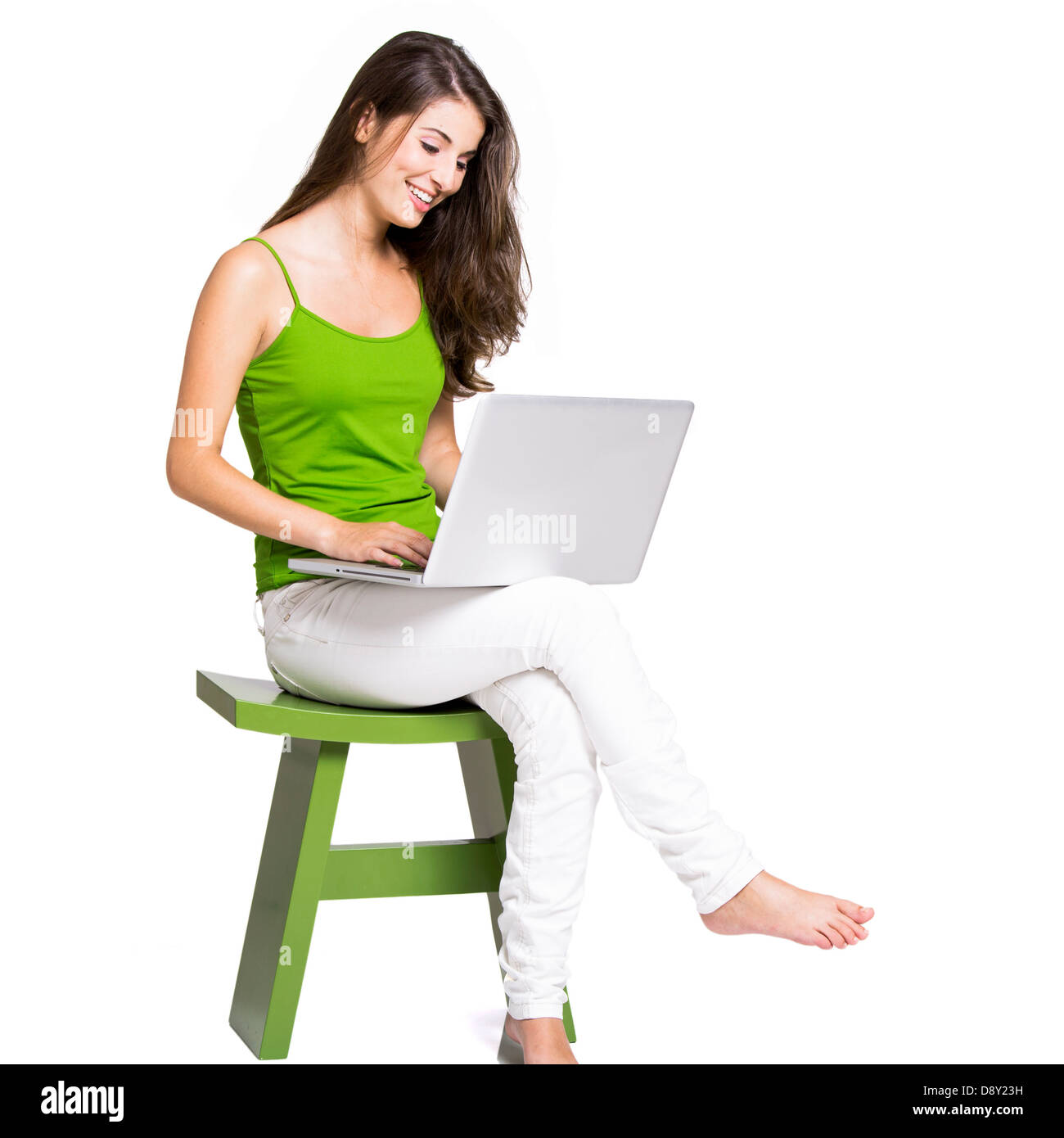 Beautiful woman sitting in a chair working with a laptop, isolated over ...