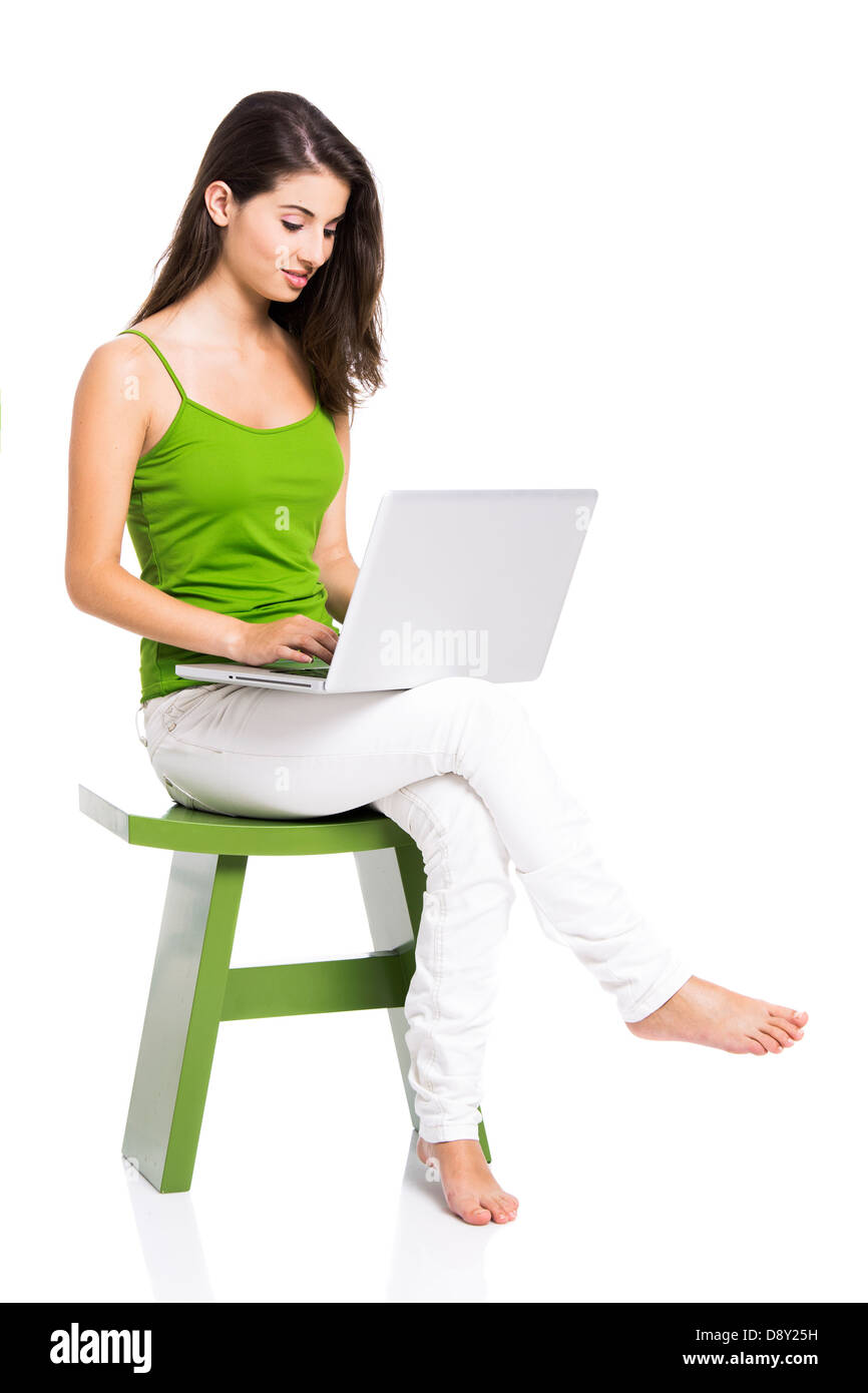 Beautiful woman sitting in a chair working with a laptop, isolated over ...