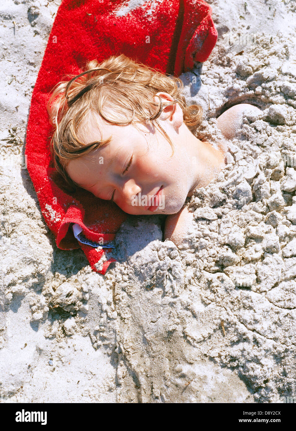 A red-haired boy that is buried in sand on a beach Stock Photo - Alamy