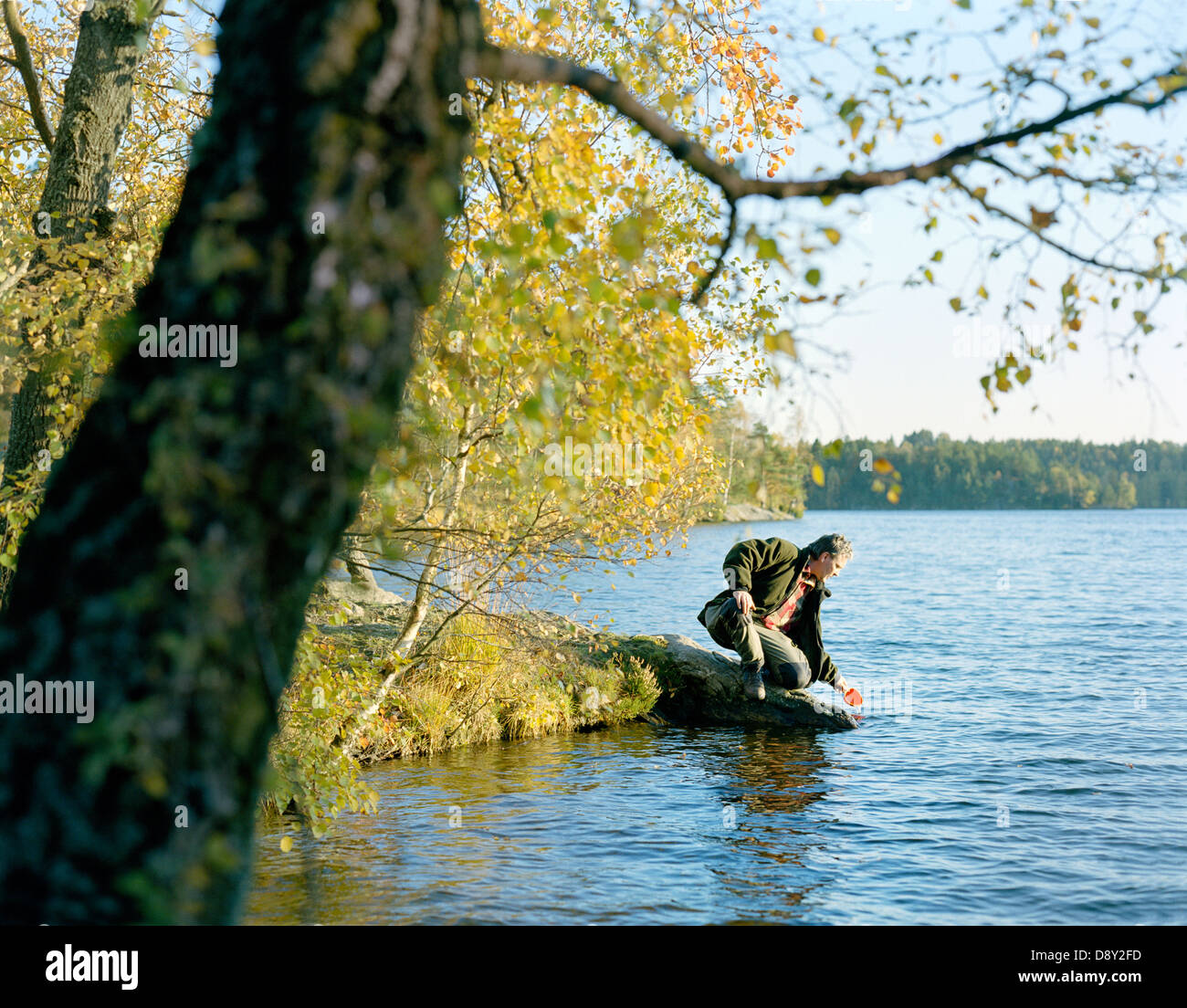 Man getting water in a lake Stock Photo - Alamy