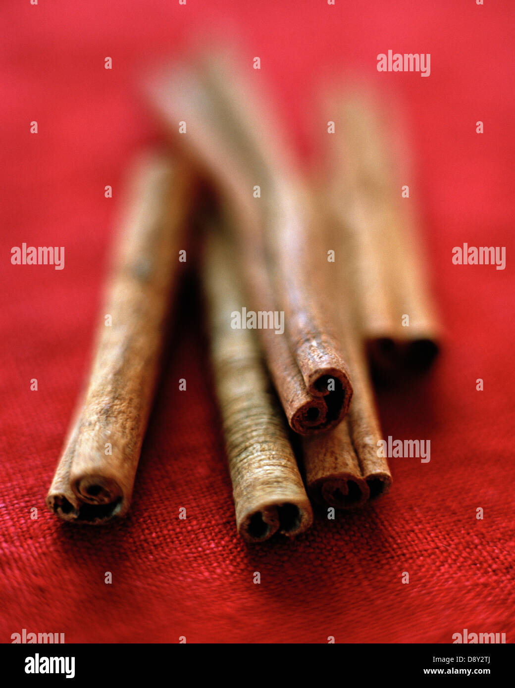 Cinnamon on a red background Stock Photo - Alamy