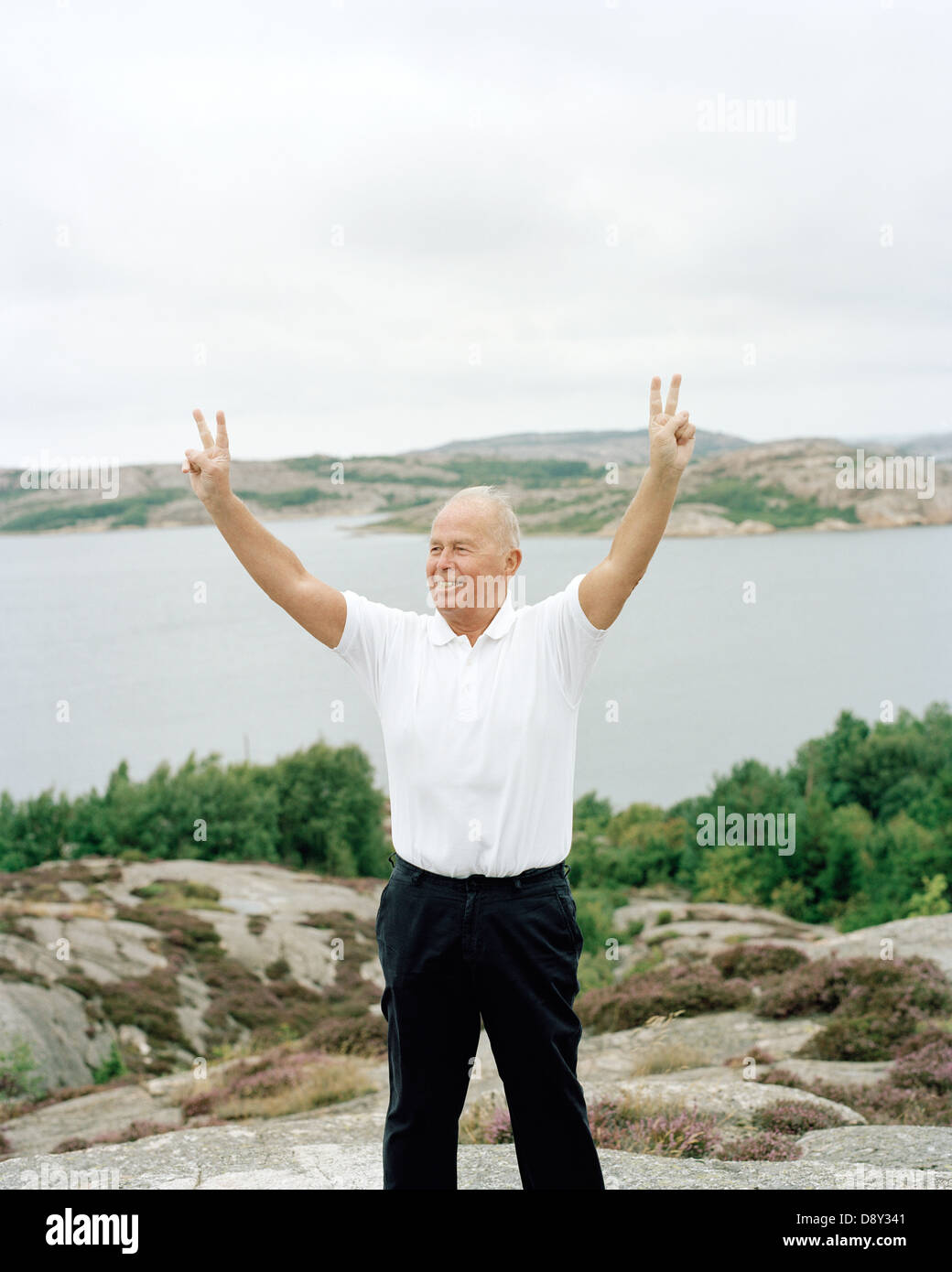 A man standing by the sea making a victory sign Stock Photo - Alamy