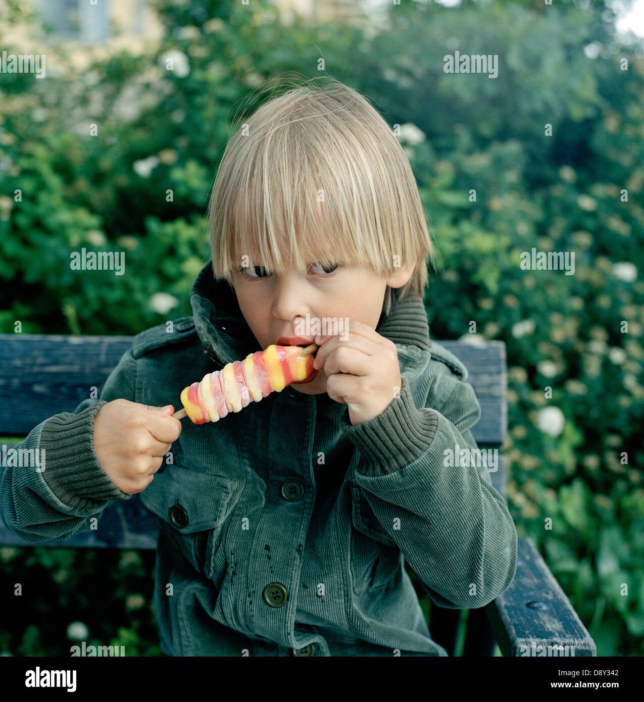 Boy Sitting on a Park Bench Eating Ice-cream Stock Photo - Alamy