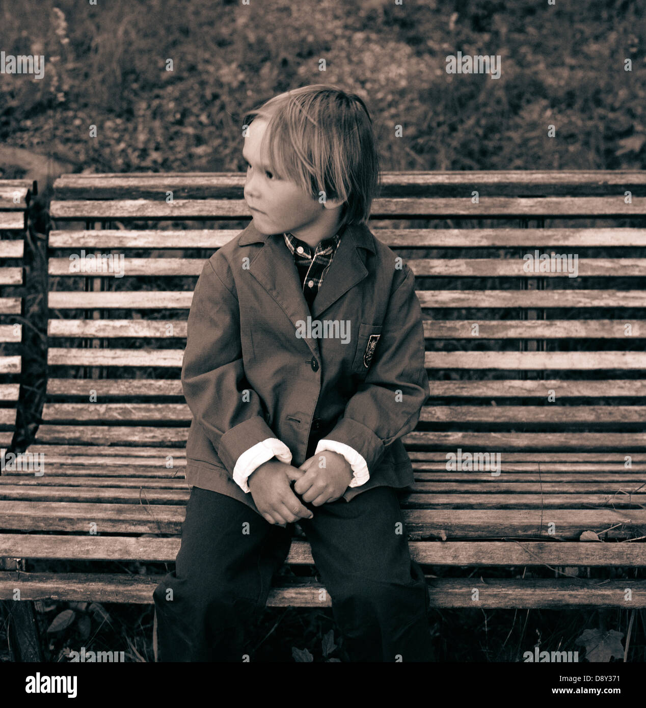 Boy Sitting on a Park Bench Stock Photo - Alamy