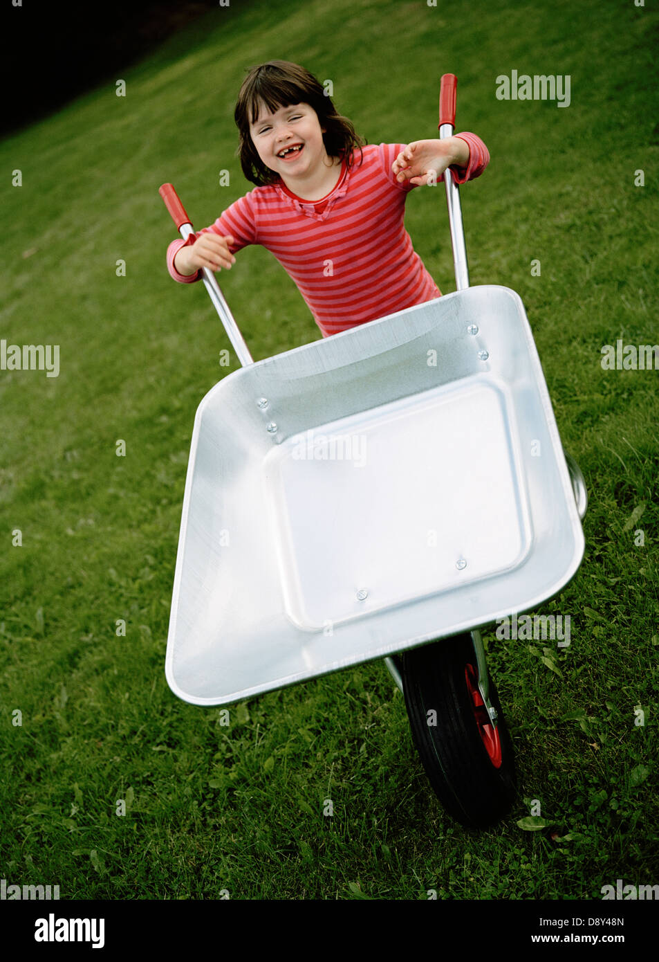 A happy girl with a wheelbarrow Stock Photo - Alamy
