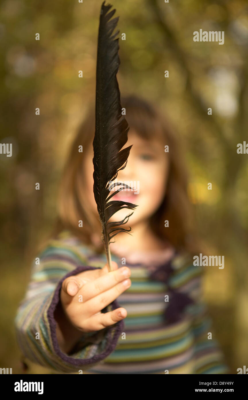 A girl holding a feather Stock Photo - Alamy