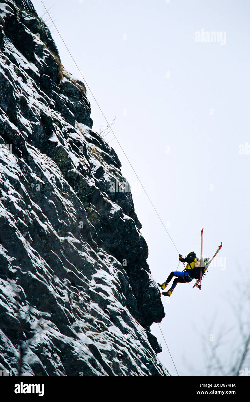 A man mountain climbing with skis on his back Stock Photo - Alamy