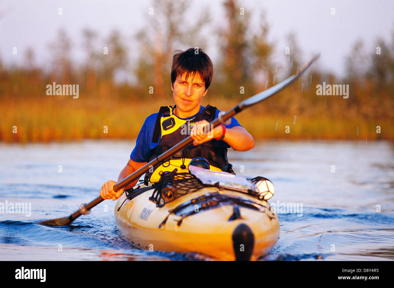 A smiling woman paddling a kayak Stock Photo - Alamy