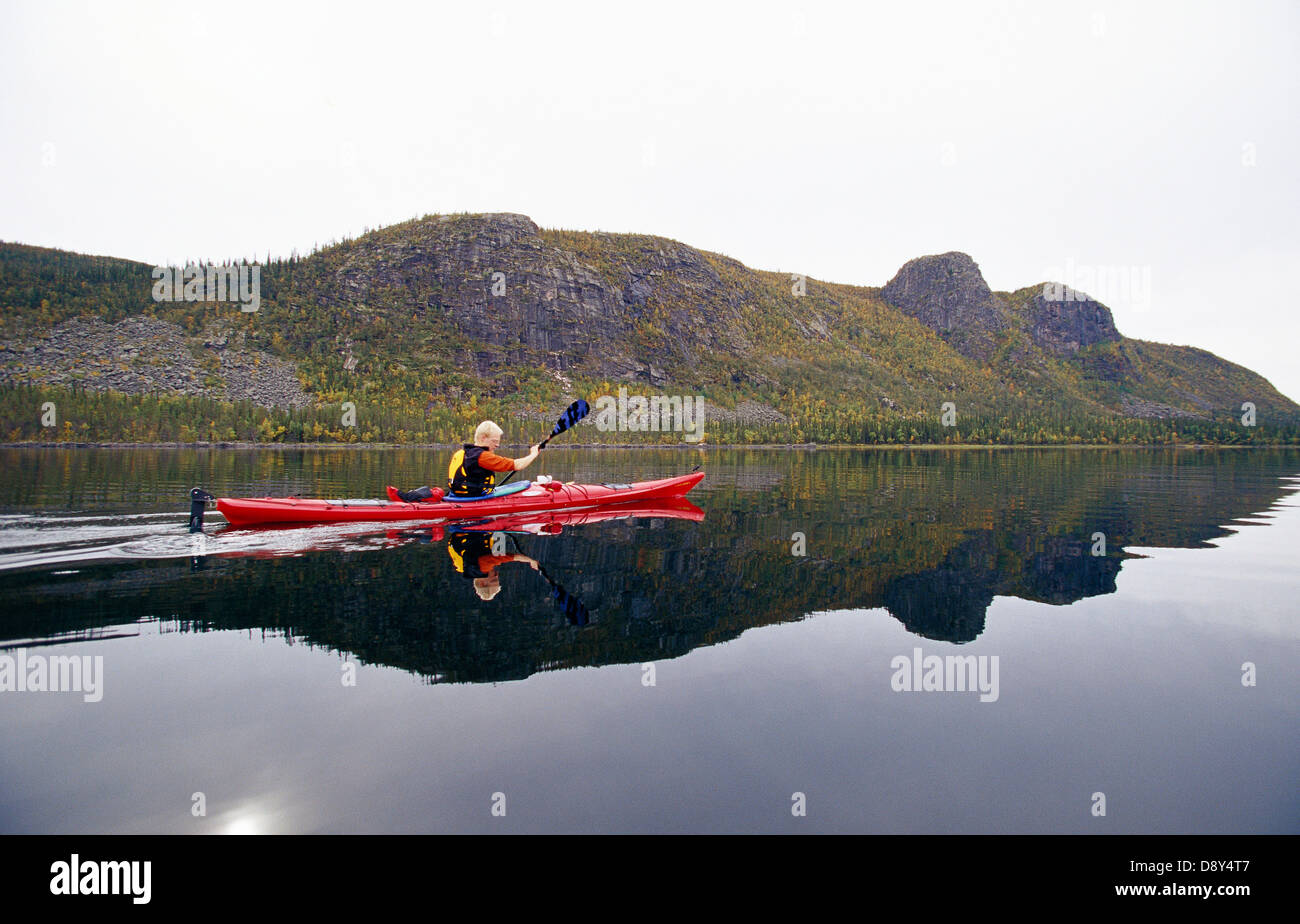 A person paddling a kayak on calm water Stock Photo - Alamy
