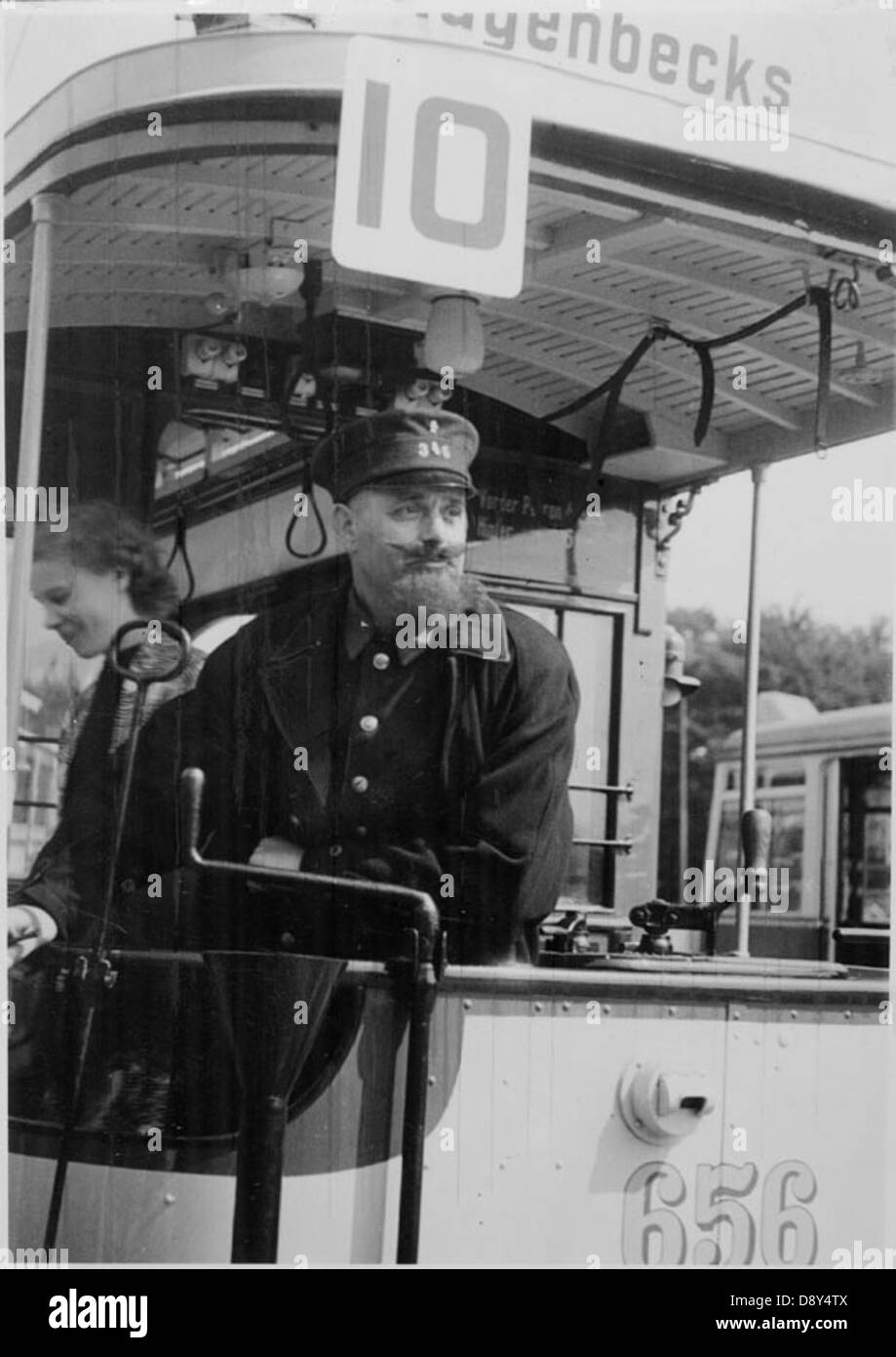 A historical photograph featuring a tram driver operating a tram in ...