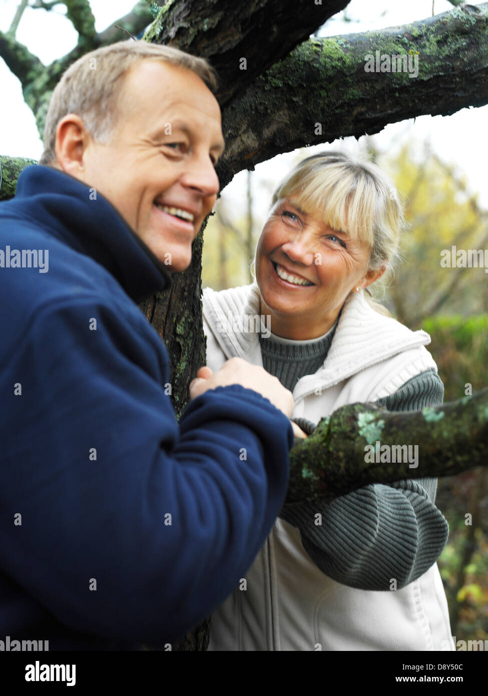 A smiling couple by a tree Stock Photo - Alamy