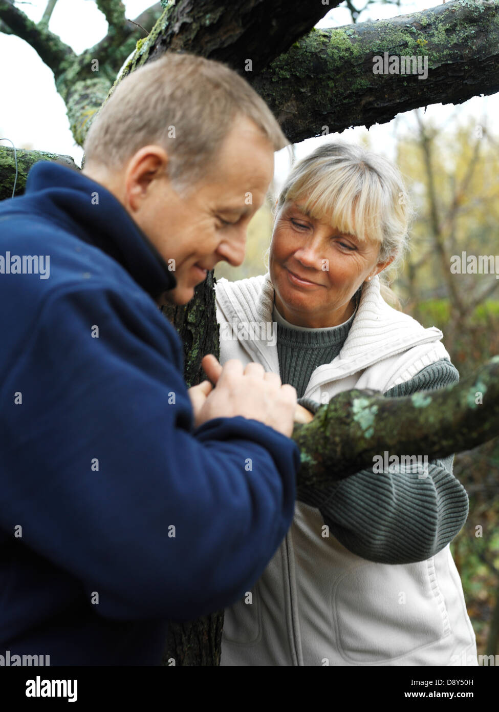 A smiling couple by a tree Stock Photo - Alamy