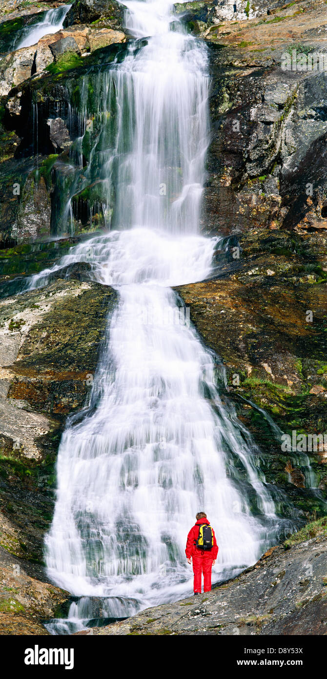 A person standing by a waterfall Stock Photo - Alamy
