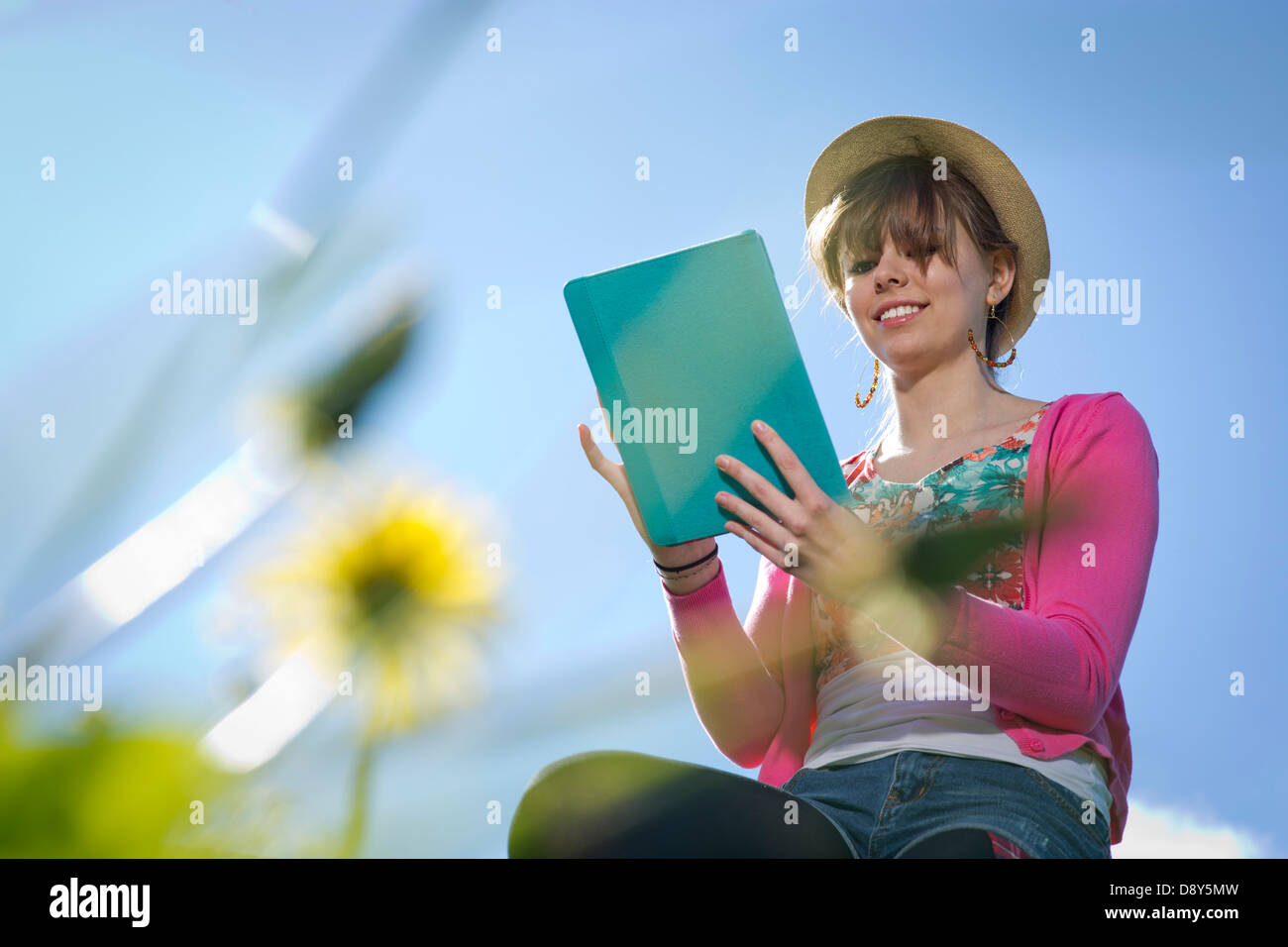 Teenage girl sitting on gate with ipad Stock Photo - Alamy