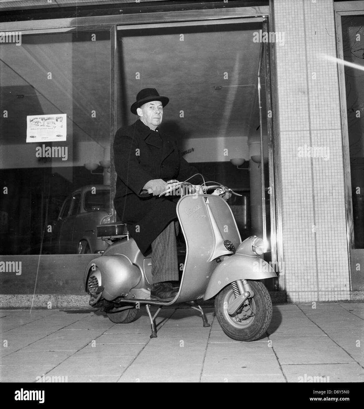 This 1952 photograph shows a man riding a Vespa scooter through the ...
