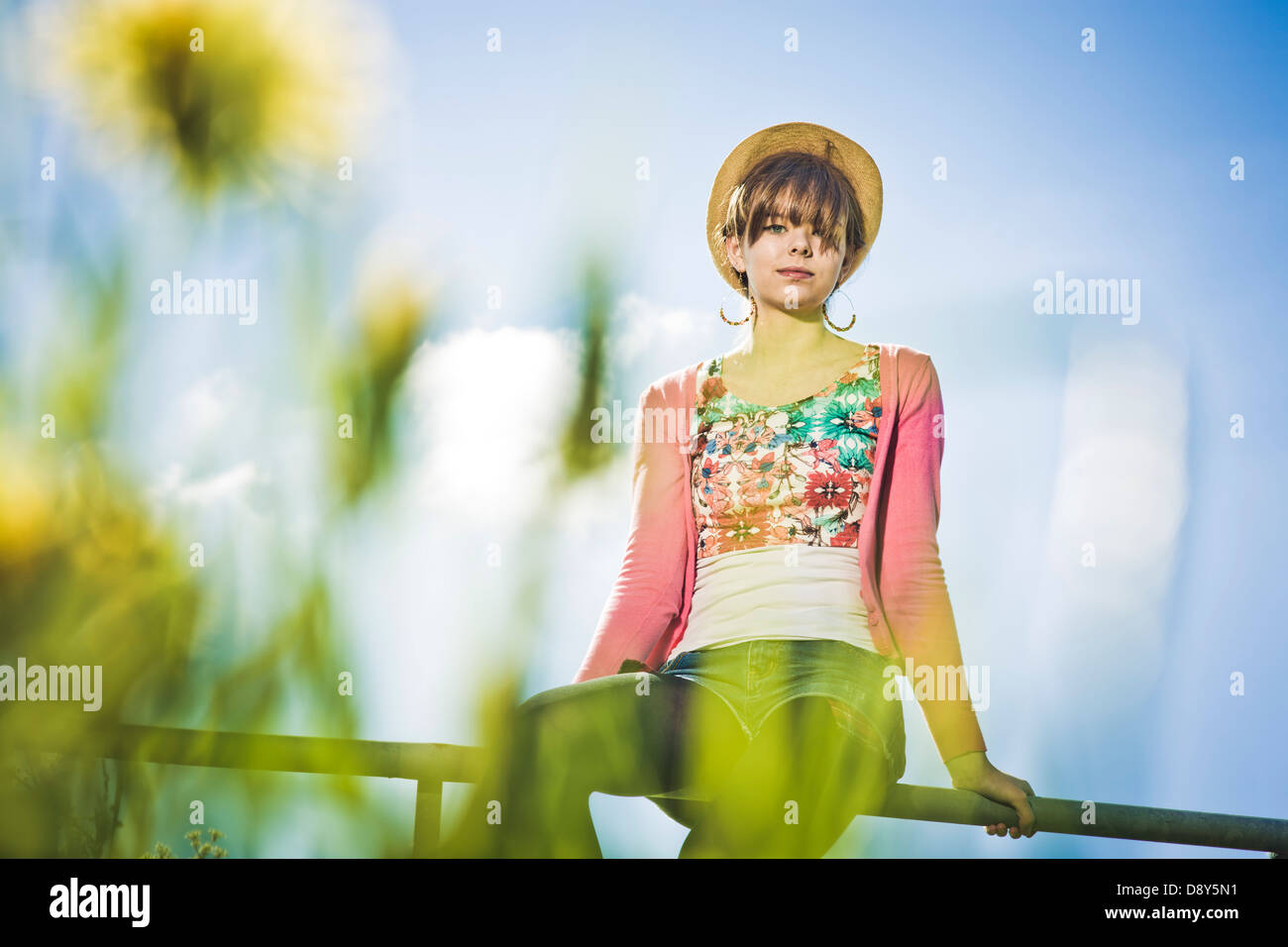 Teenage girl sitting on gate Stock Photo - Alamy