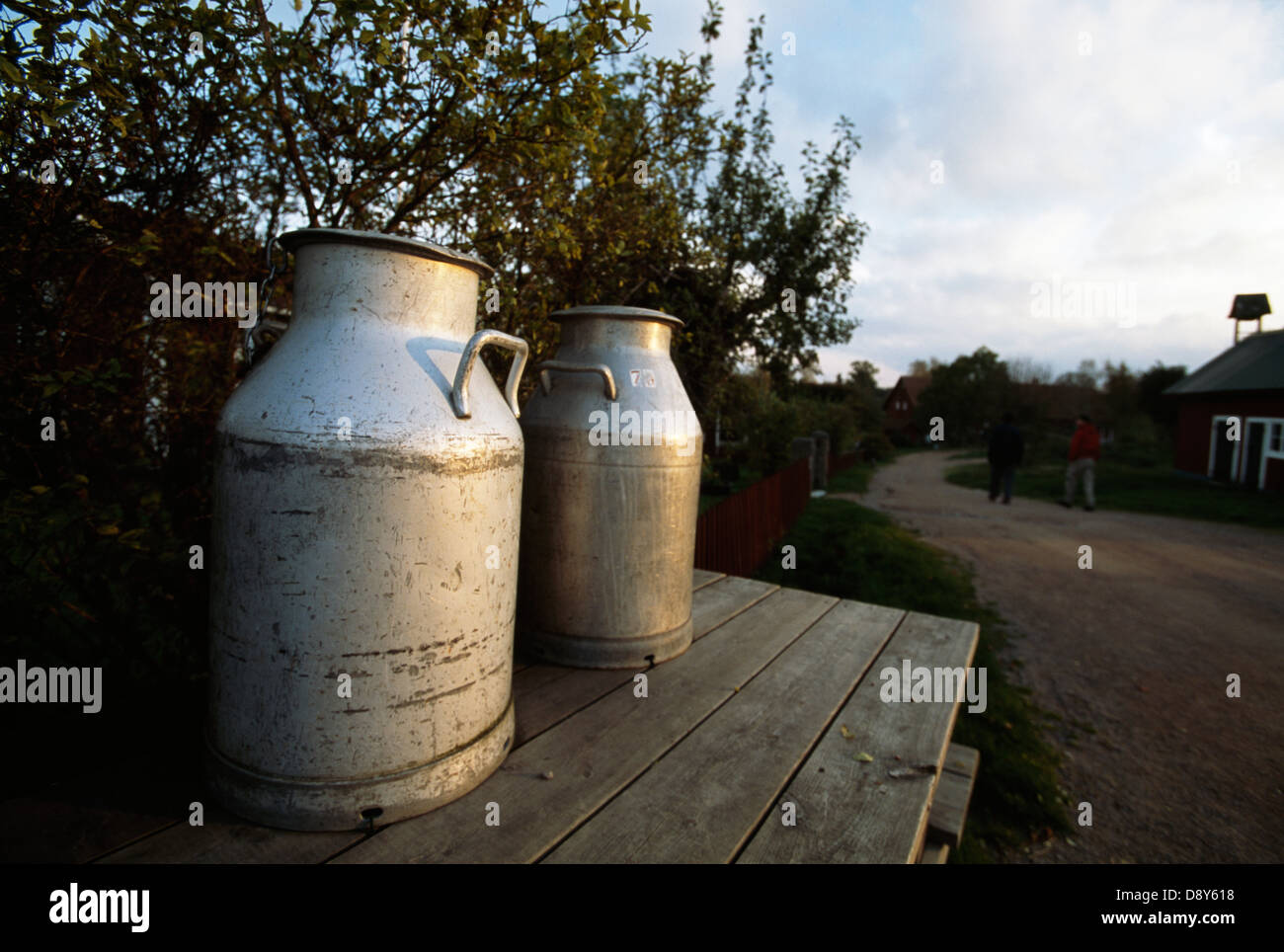 Milk cans on a bench Stock Photo - Alamy