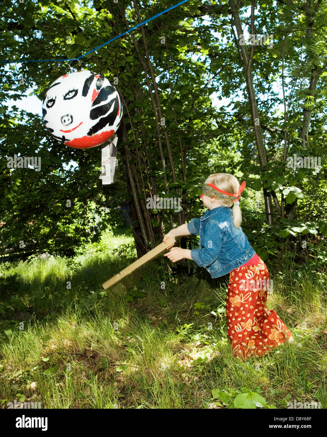 A girl trying to hit a pinata Stock Photo - Alamy