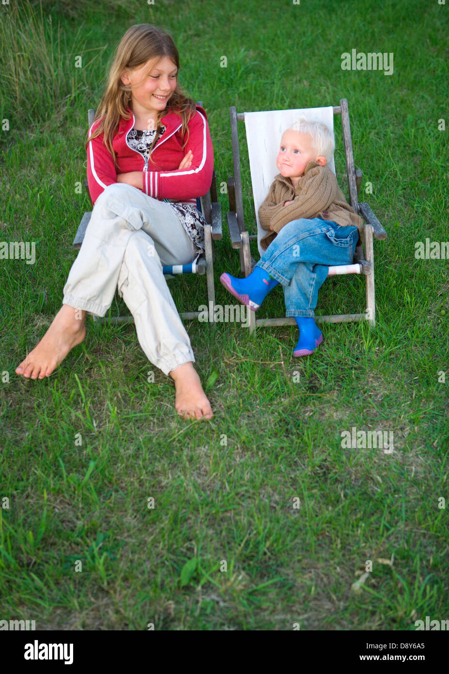 Two girls sitting on chairs hi-res stock photography and images - Alamy