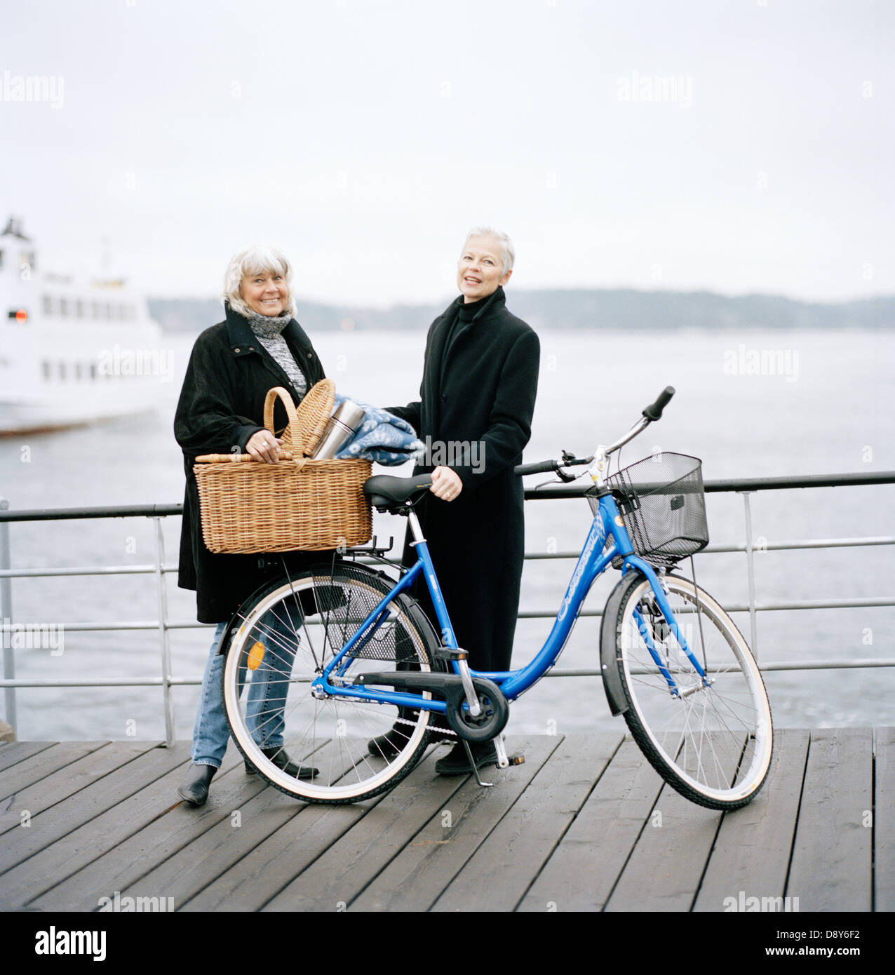 Two women and a bike on a jetty Stock Photo - Alamy