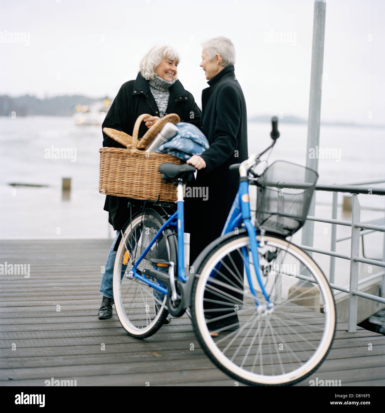 Two women and a bike on a jetty Stock Photo - Alamy