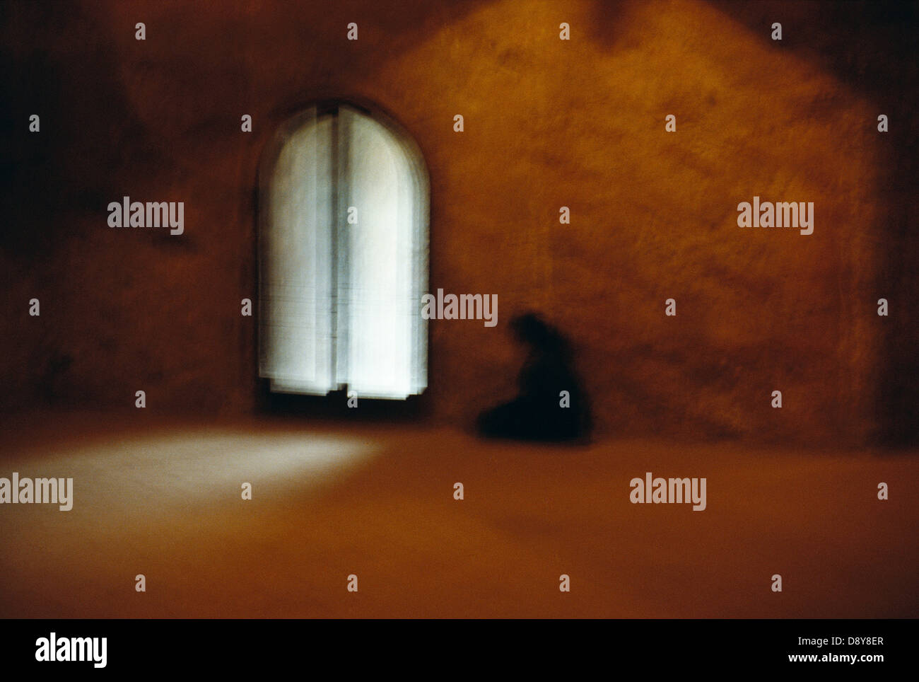 Woman on her knee by a window Stock Photo - Alamy