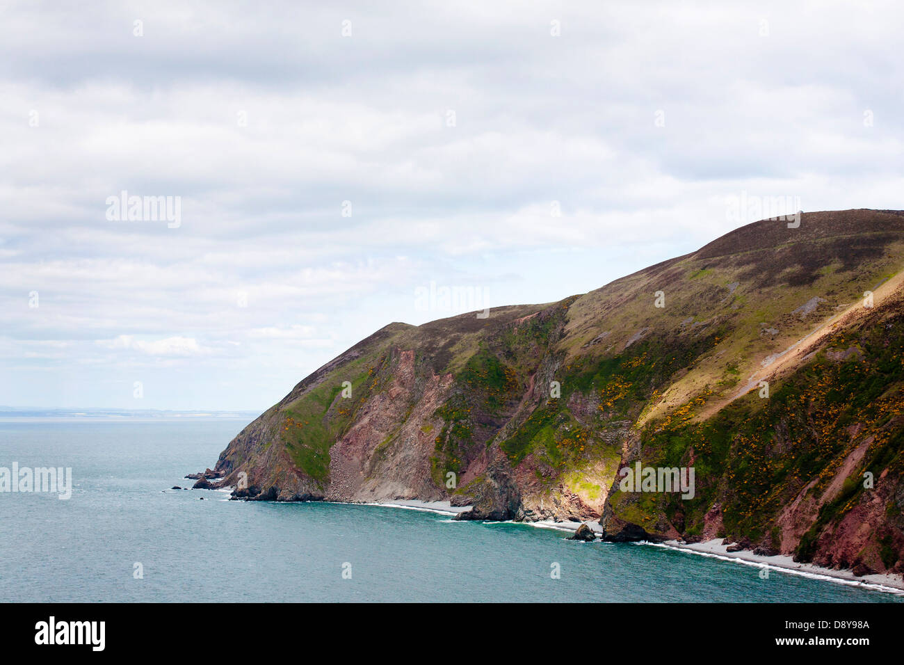 Exmoor meets the sea with a patch of sunlight, North Devon Coast, UK ...