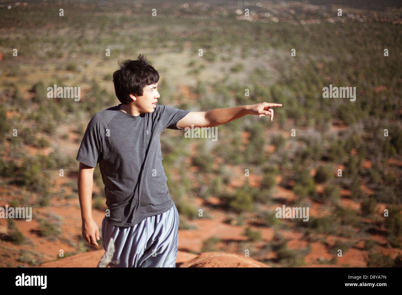 Young man pointing to direct Stock Photo - Alamy