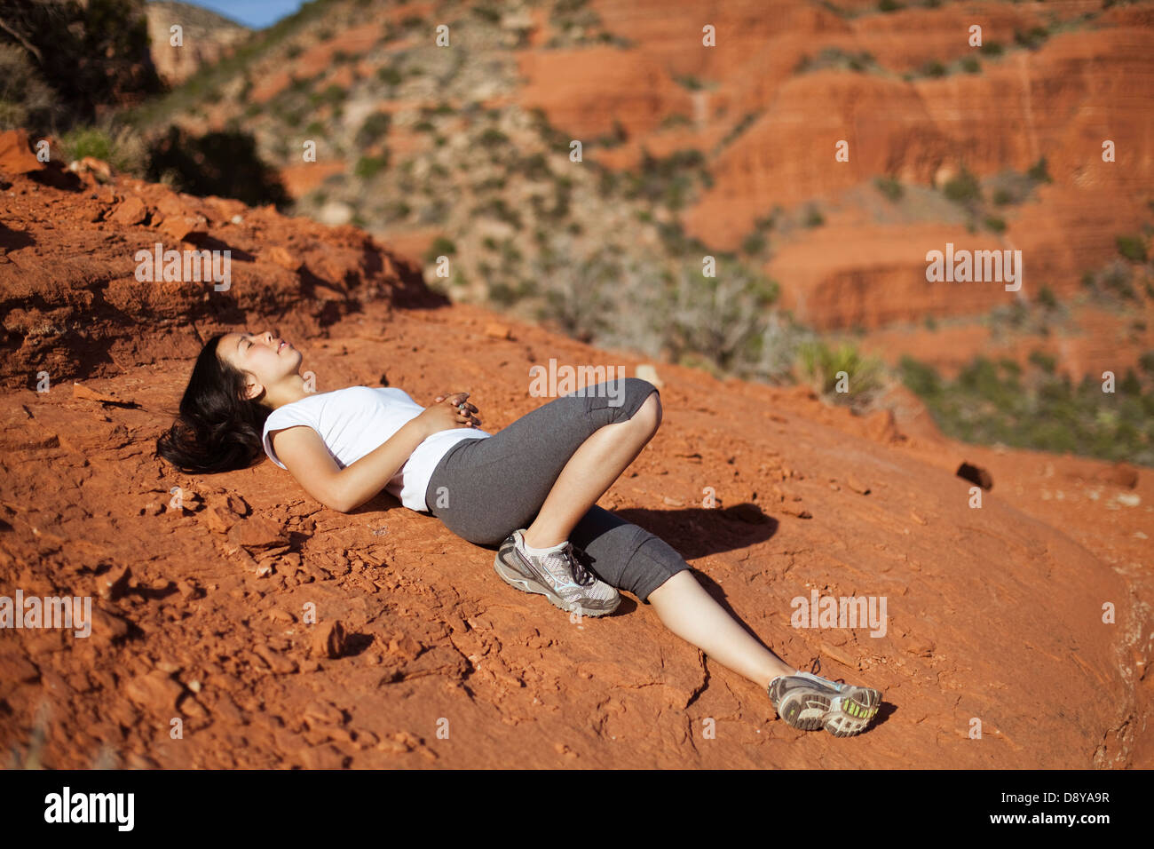 Young woman laying on rocks in Sedona Arizona Stock Photo - Alamy