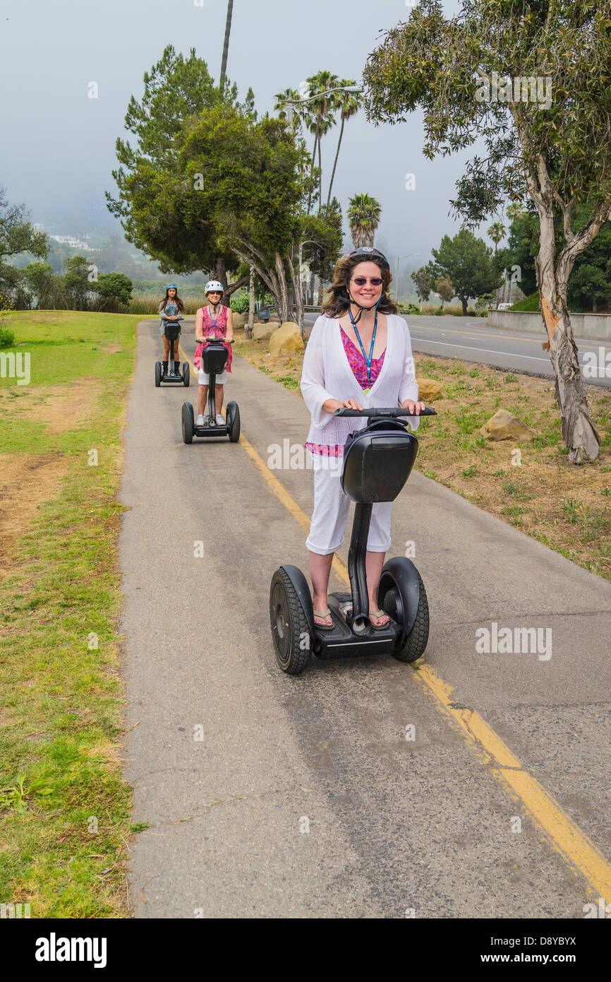 A group of Segway personal transporter riders wearing helmets drive ...