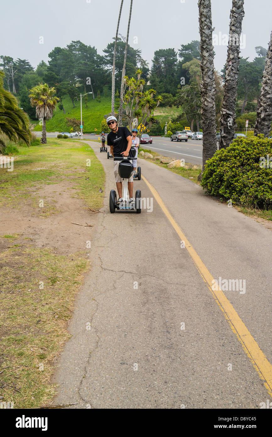 A group of Segway personal transporter riders wearing helmets drive ...