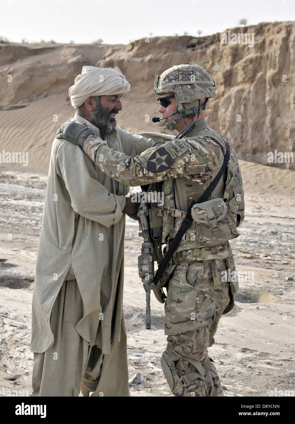 US Army Capt. Troy Yoho exchanges greetings with an Afghan farmer while ...